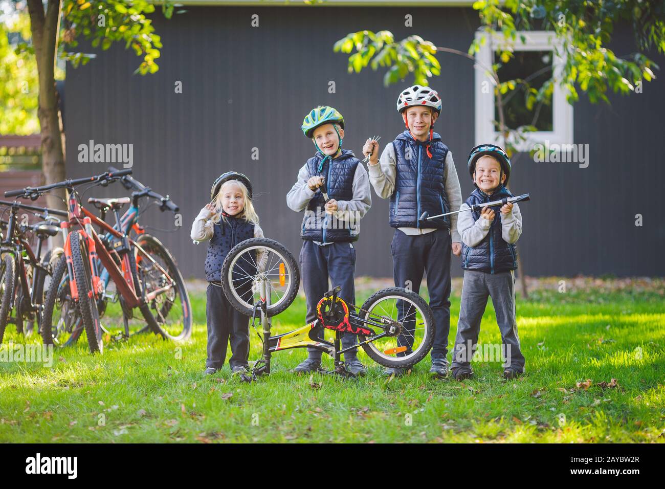 Children mechanics, bicycle repair. Happy kids fixing bike together ...