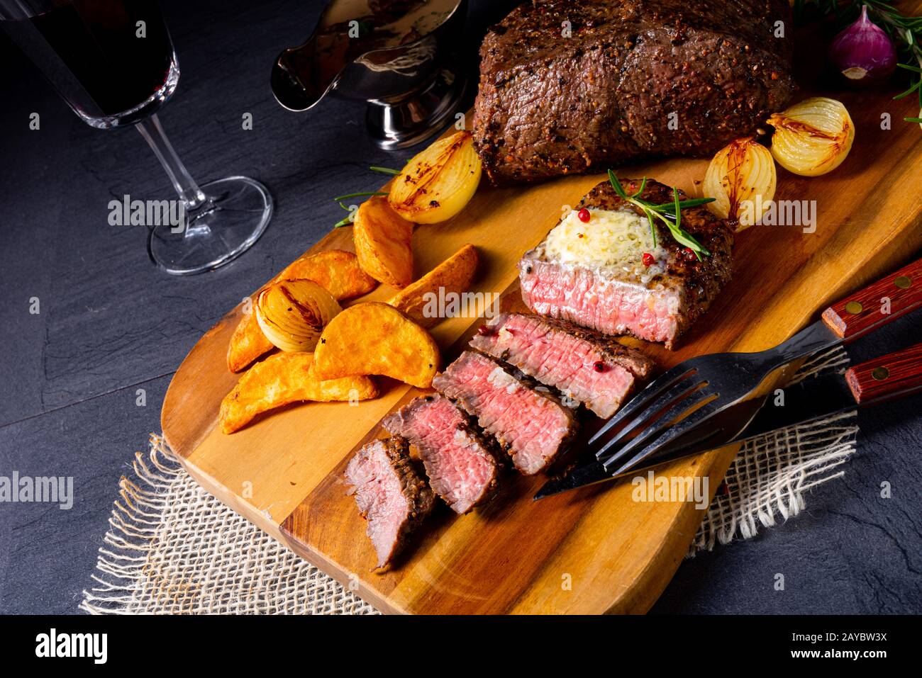 rustic medium butter beef steak with herbs and potato wedges Stock ...