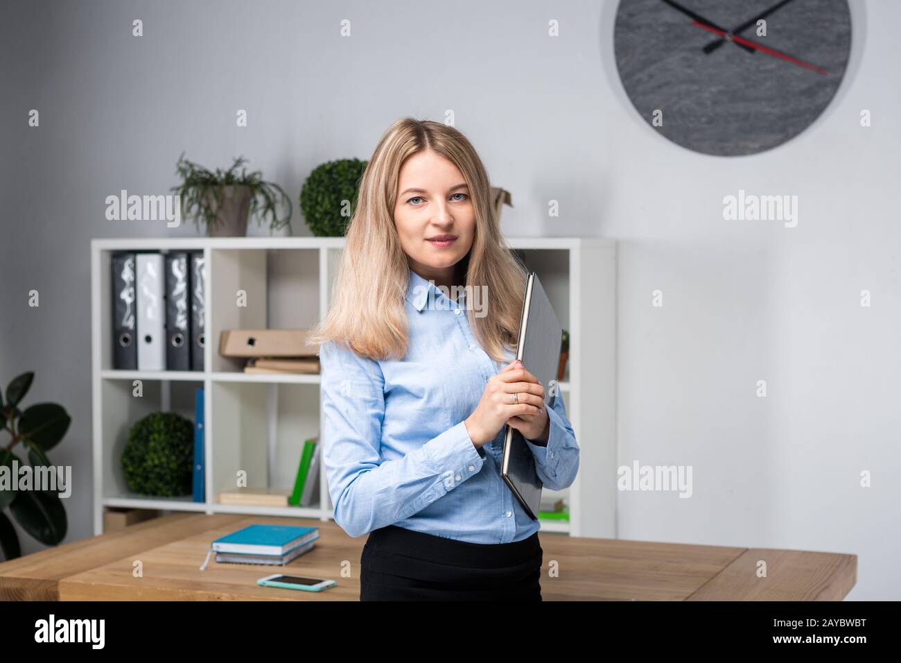 Businesswoman Holding Large File. young womanl standing in the office ...