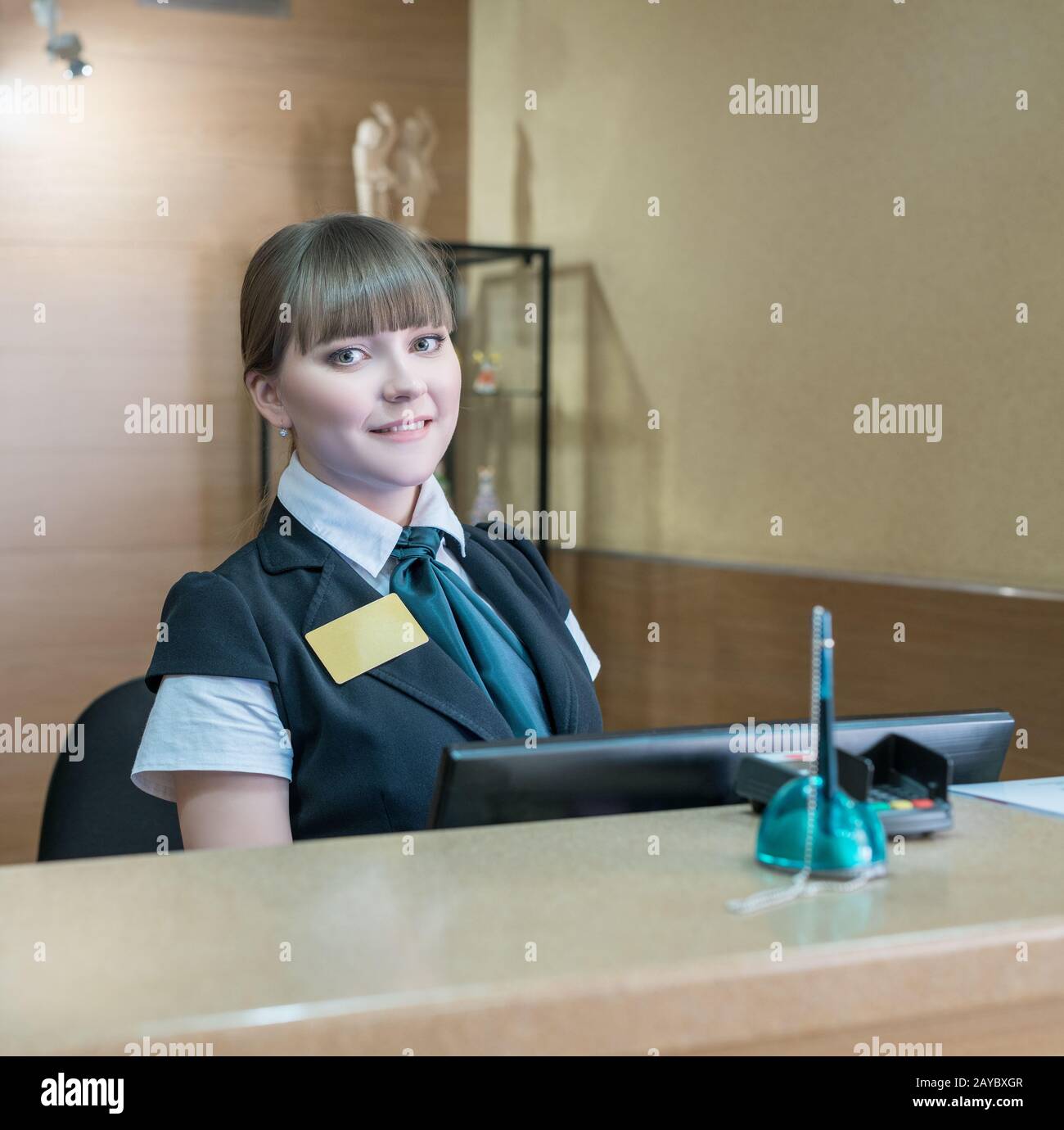Hotel reception. Pretty hostess smiling at camera Stock Photo - Alamy
