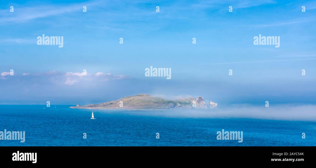 Low lying mist covering Irelands Eye island, view from Howth, Ireland ...