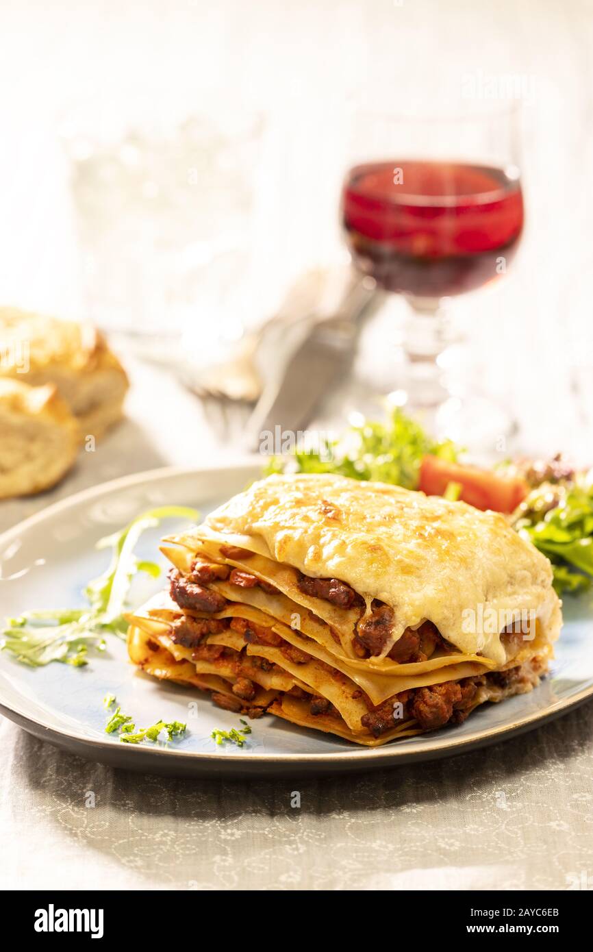 Portion of lasagne with wine Stock Photo - Alamy