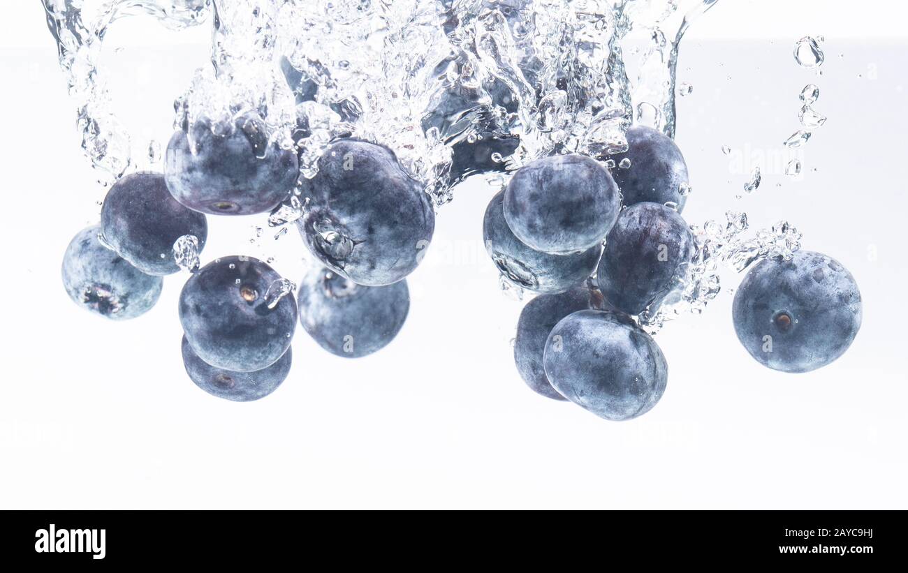 Bunch of blueberries splashing into water surface and sinking. Isolated ...