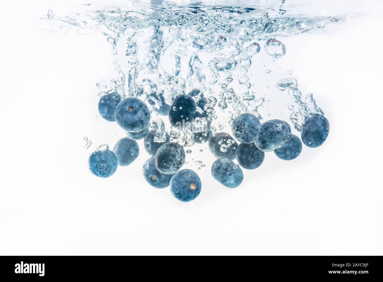 Bunch of blueberries splashing into water surface and sinking. Isolated ...