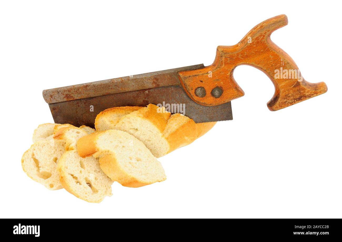 Old wooden handled saw sawing a crusty bread baguette isolated on a ...