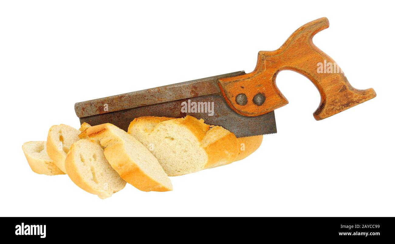Old wooden handled saw sawing a crusty bread baguette isolated on a ...