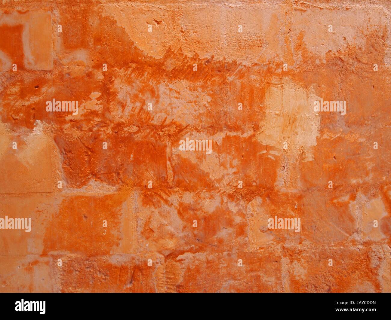 an old distressed patched orange stone wall painted in different shades ...