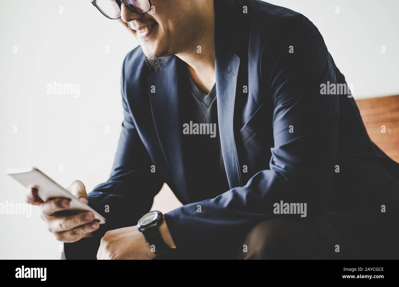 Portrait of happy young businessman using cell phone at street market ...