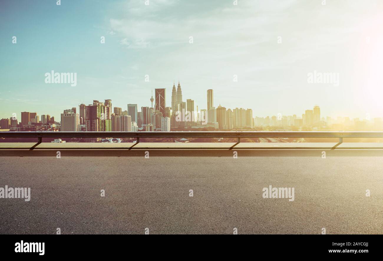 Empty asphalt road with city skyline background Stock Photo - Alamy