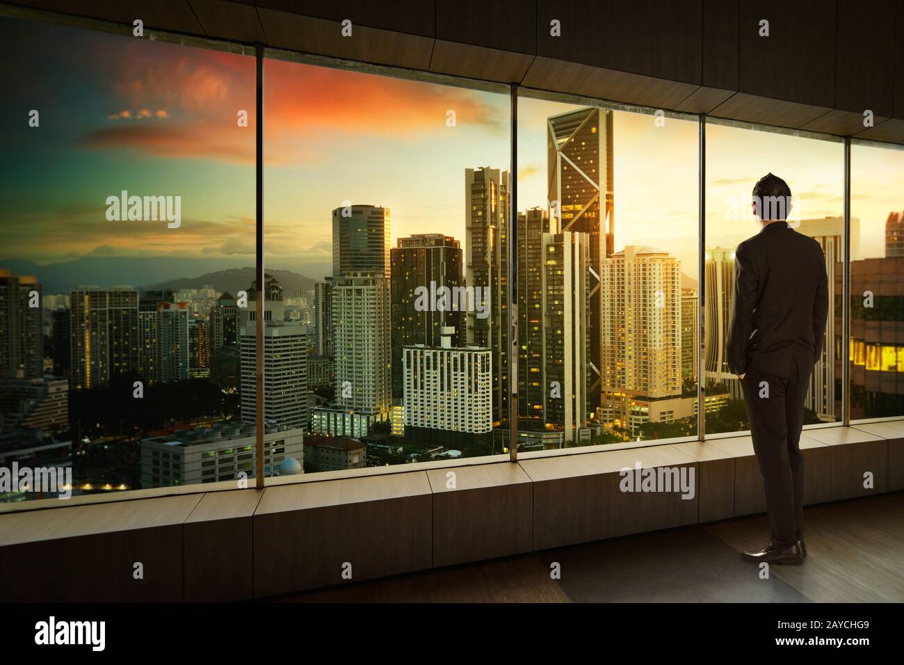 Businessman looking and thinking front of a window office with modern ...