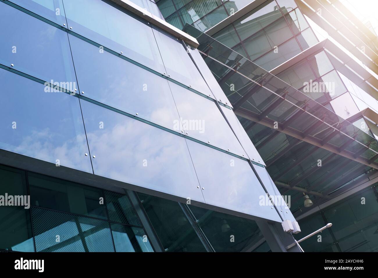 Modern facade of glass and steel with window reflecting sky and clouds ...
