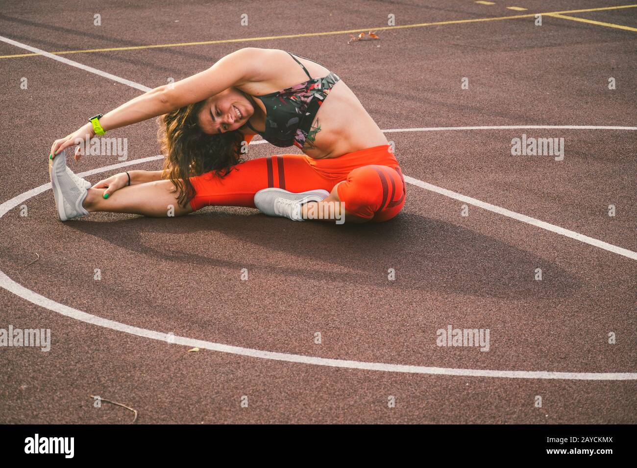Woman Athlete Stretching Legs On Stadium Female Runner Stretching