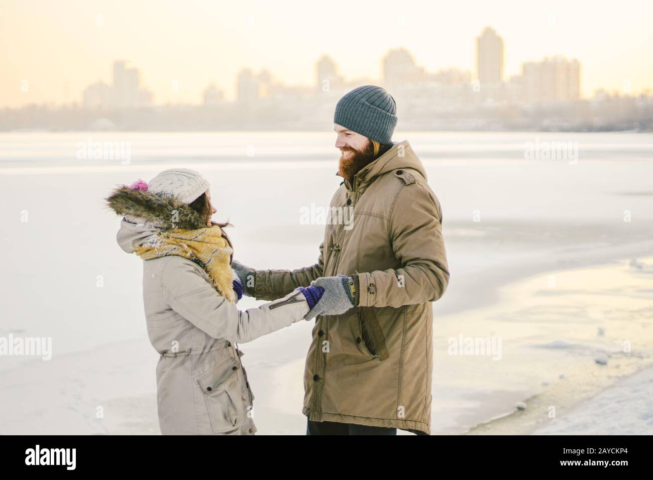 Young couple cheerfully flounders in snow. Between comic fight. Happy ...