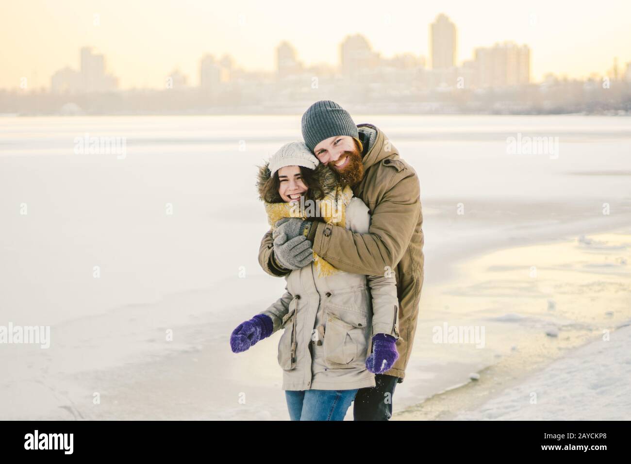 Young couple cheerfully flounders in snow. Between comic fight. Happy ...