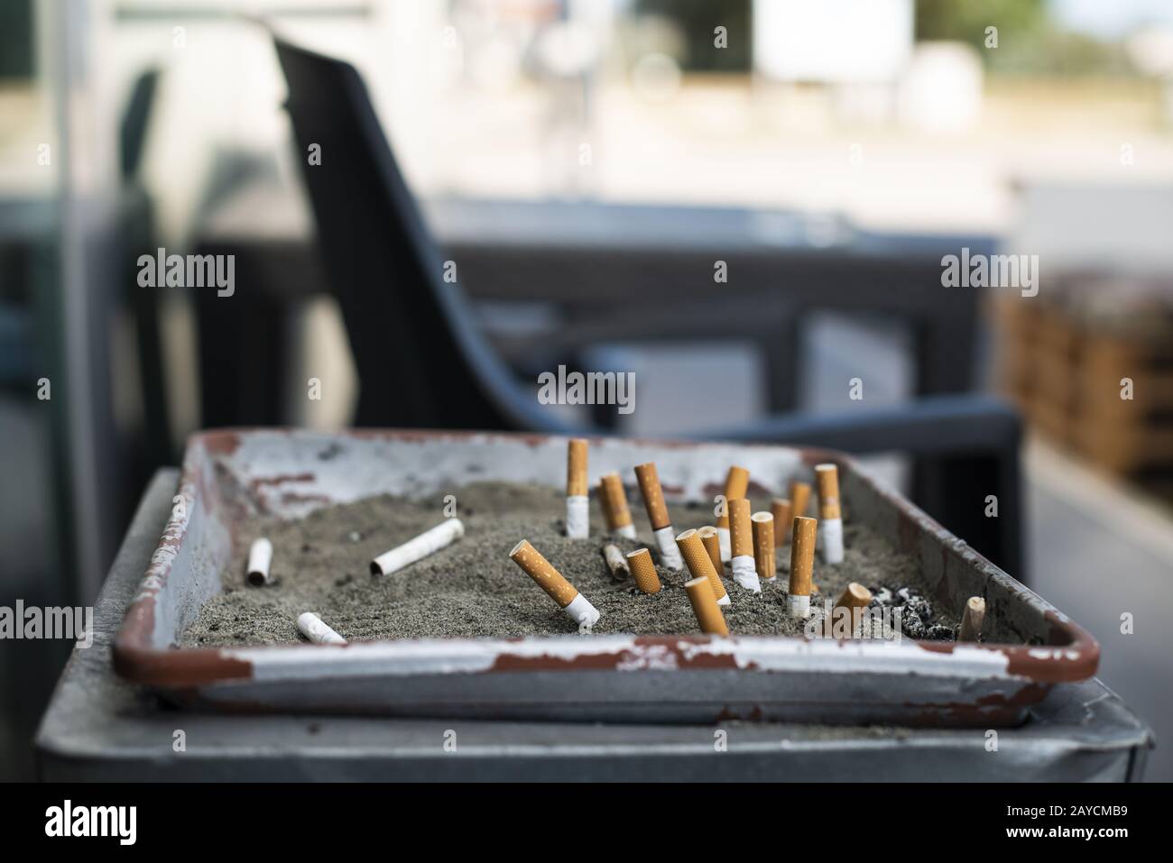 Ashtray with sand and buried cigarettes Stock Photo - Alamy