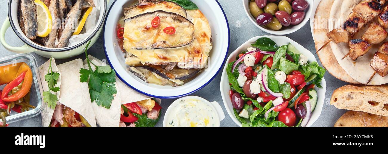 Greek food on grey background. Moussaka, gyros,souvlaki, pita, salad ...