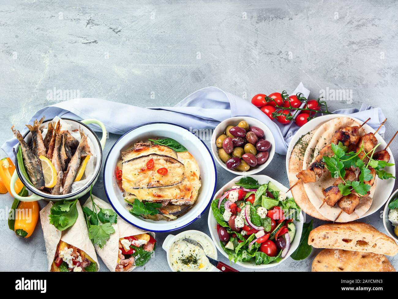 Greek food on grey background. Moussaka, gyros,souvlaki, pita, salad ...