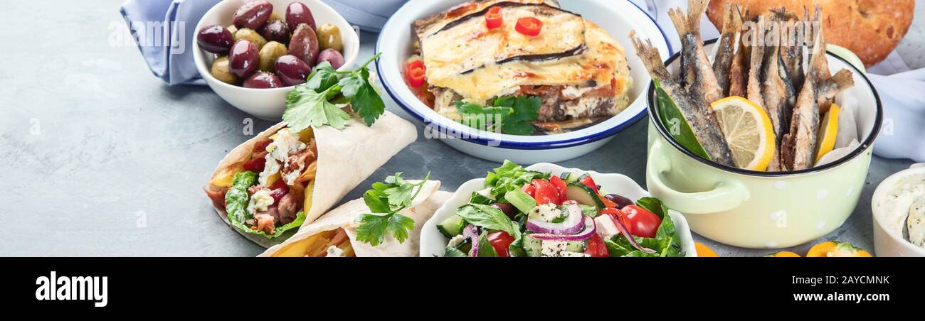 Greek food on grey background. Moussaka, gyros,souvlaki, pita, salad ...