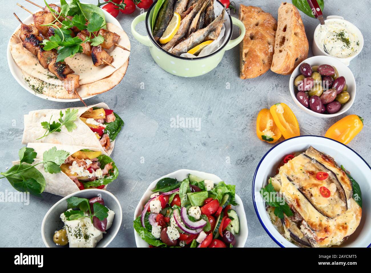 Greek food on grey background. Moussaka, gyros,souvlaki, pita, salad ...