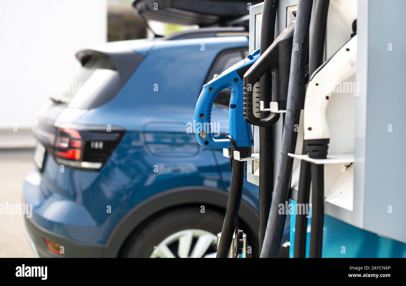 Electric car on gas station. Blue car and electric plug for charging ...