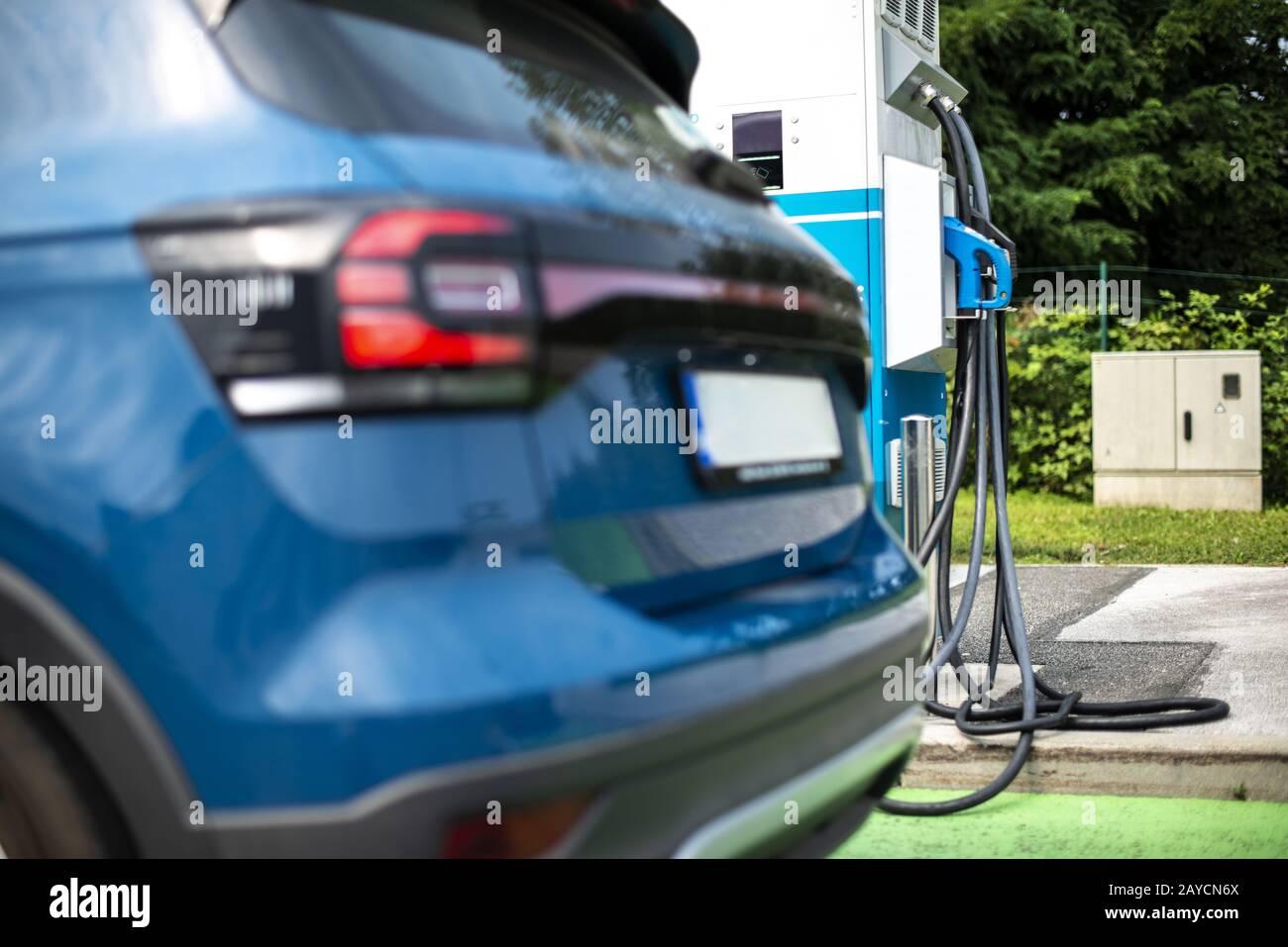 Electric car on gas station. Blue car and electric plug for charging ...