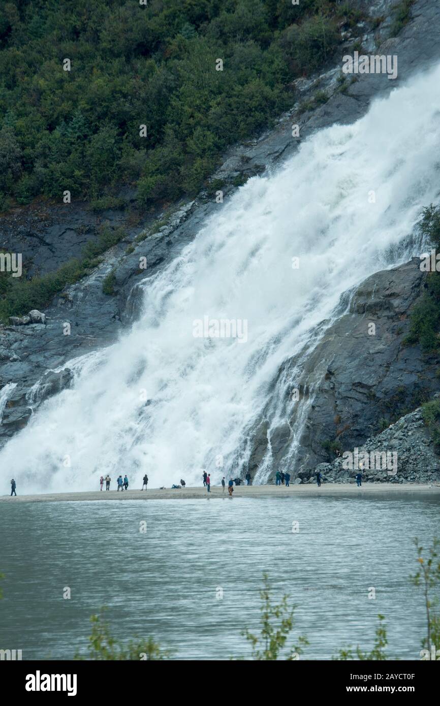 People at the Nugget Falls waterfall at the Mendenhall Glacier, near ...