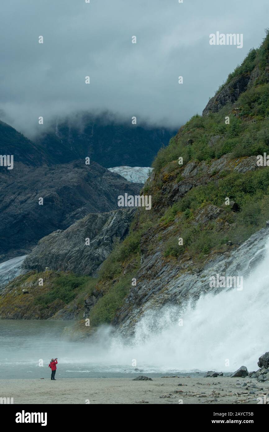 A tourist is photographing the Nugget Falls waterfall near the ...