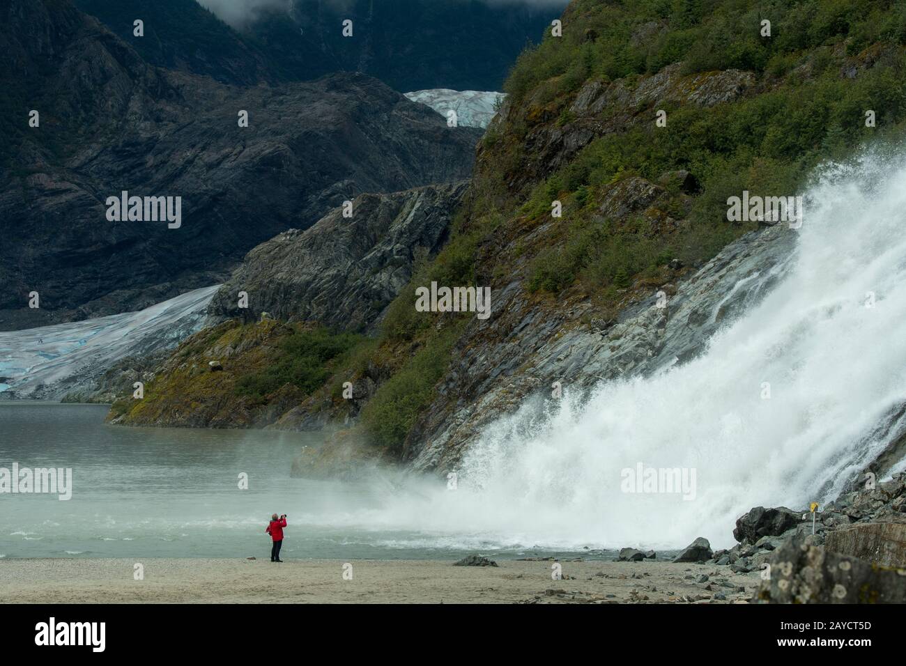 A tourist is photographing the Nugget Falls waterfall near the ...