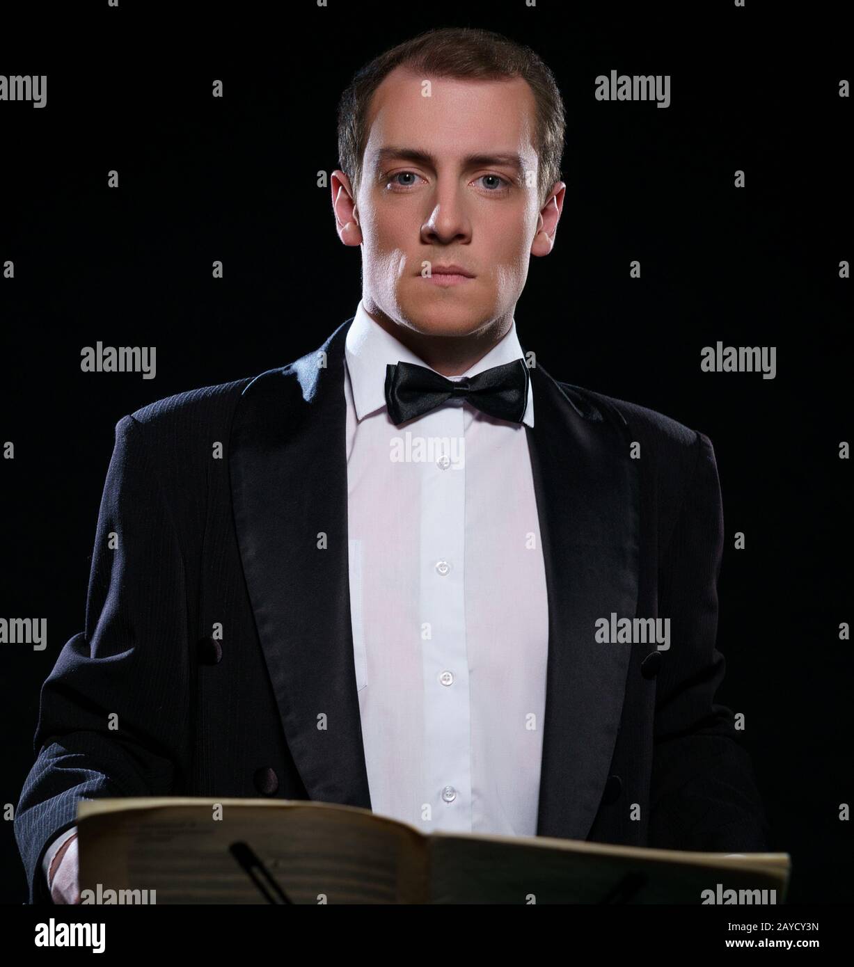 Orchestra conductor in black tuxedo in dark studio Stock Photo - Alamy