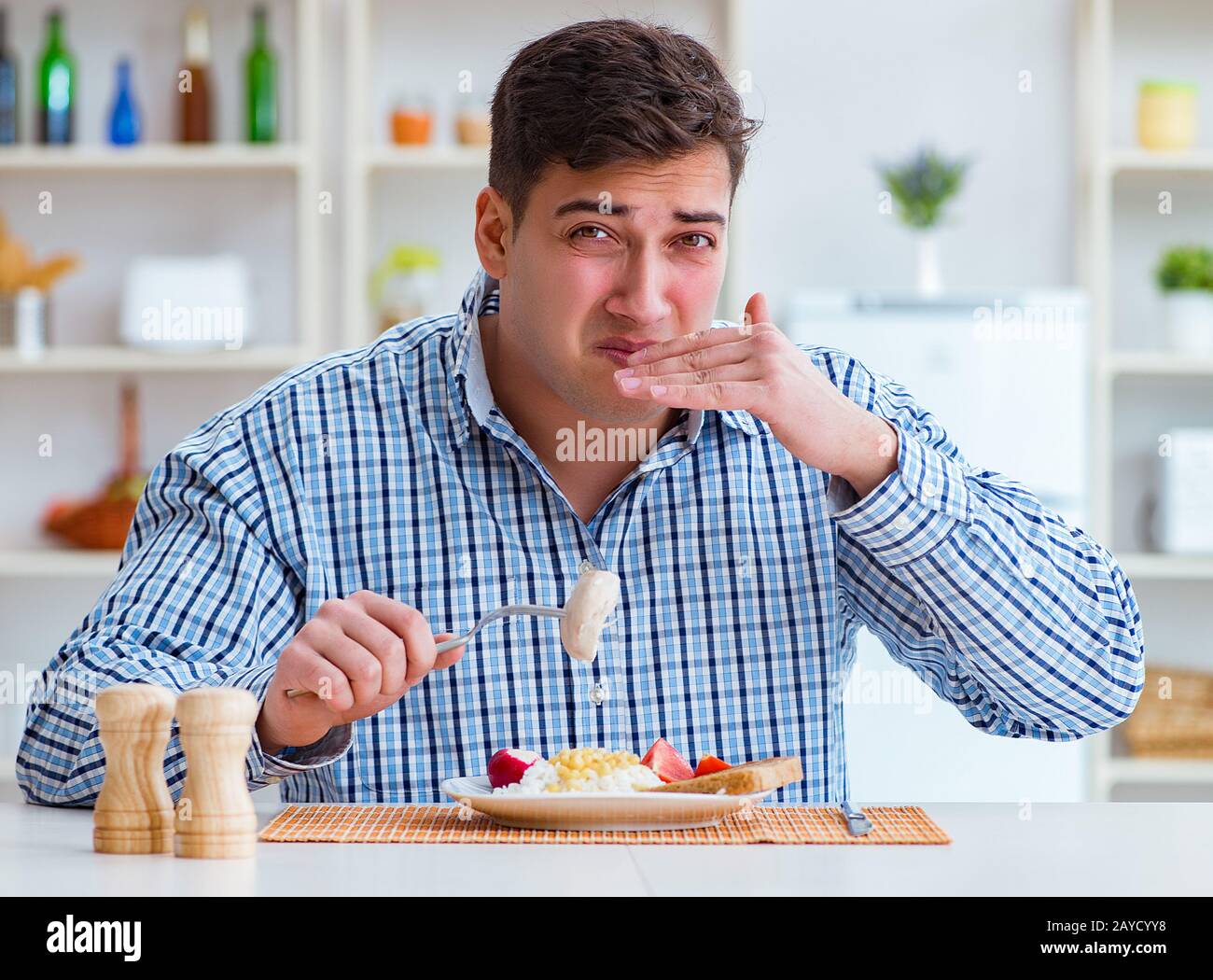 Man eating tasteless food at home for lunch Stock Photo - Alamy