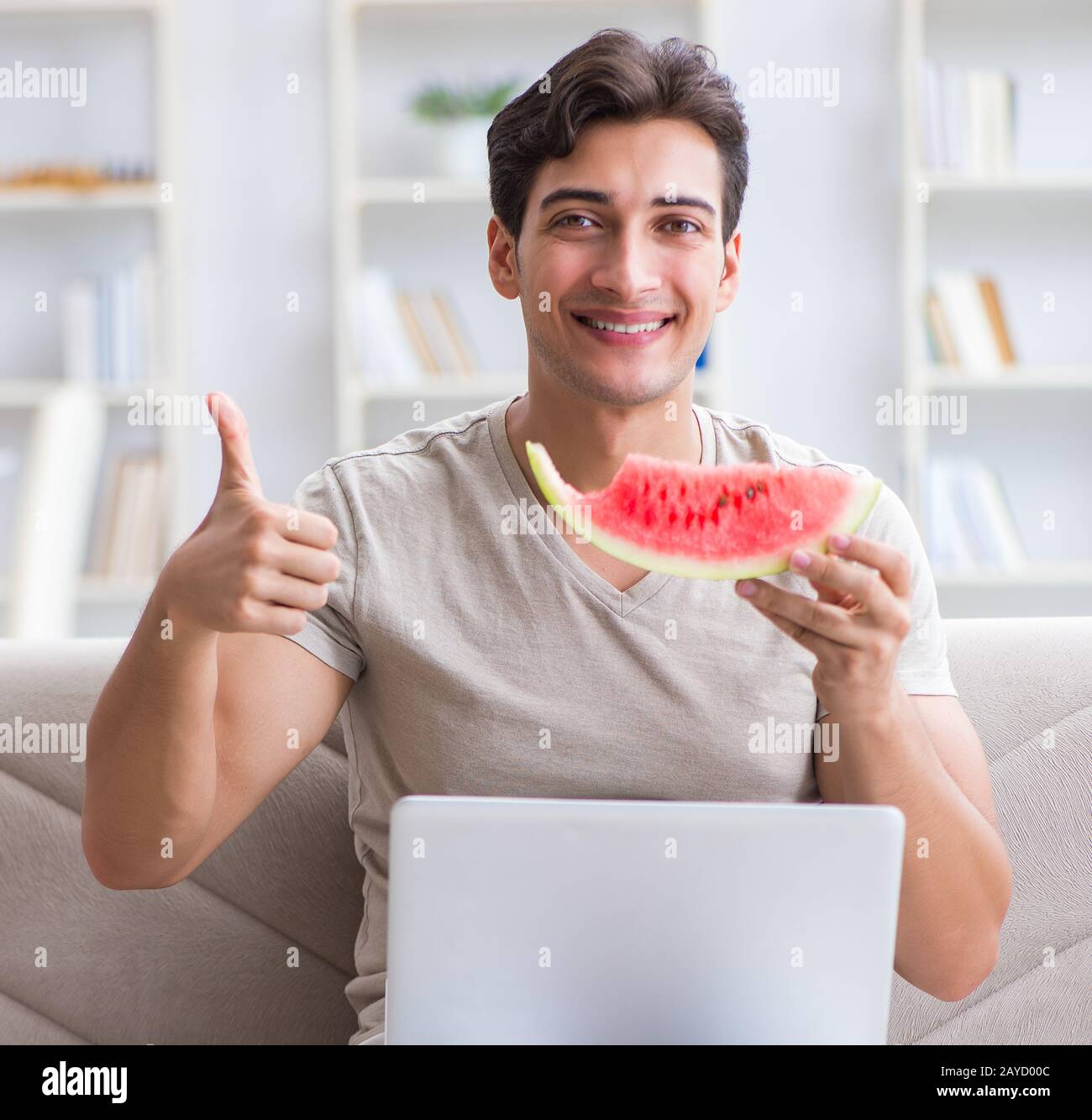Man eating watermelon at home Stock Photo - Alamy