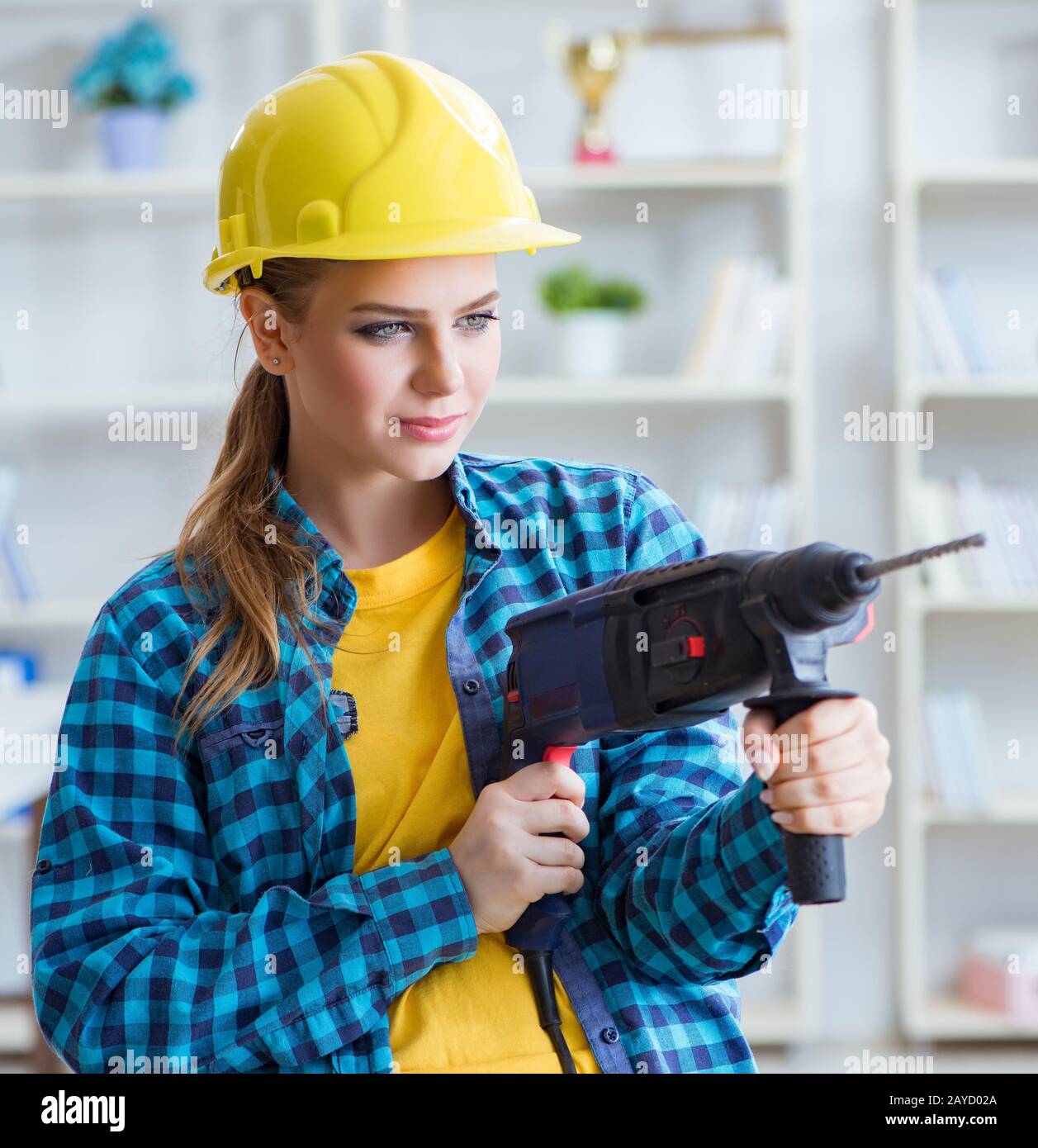 Woman in workshop with drilling drill Stock Photo - Alamy