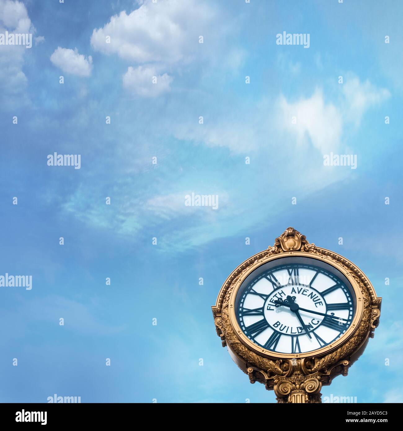 Big clock on nice bright blue sky with coulds Stock Photo - Alamy