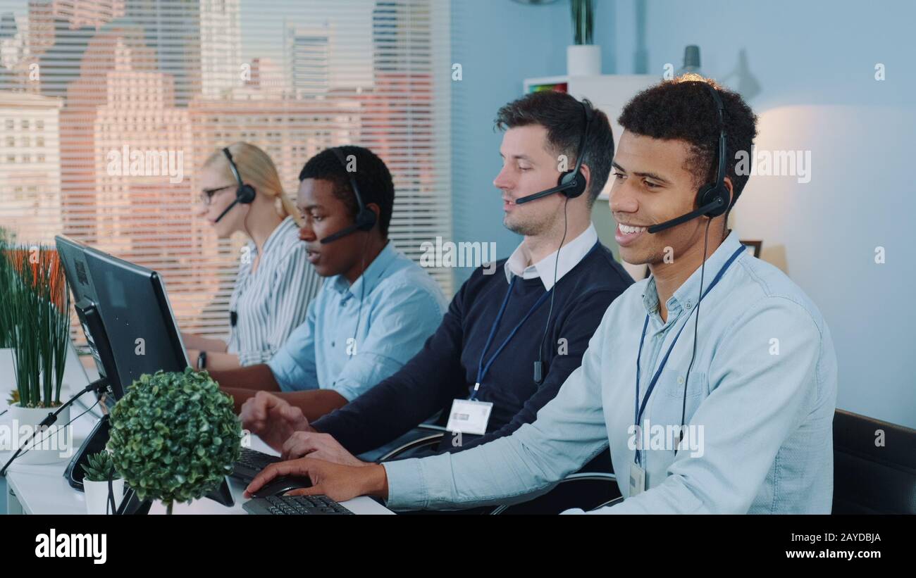 Multiracial call center agent feeling exhausted and broken-down after telephone call with the ...