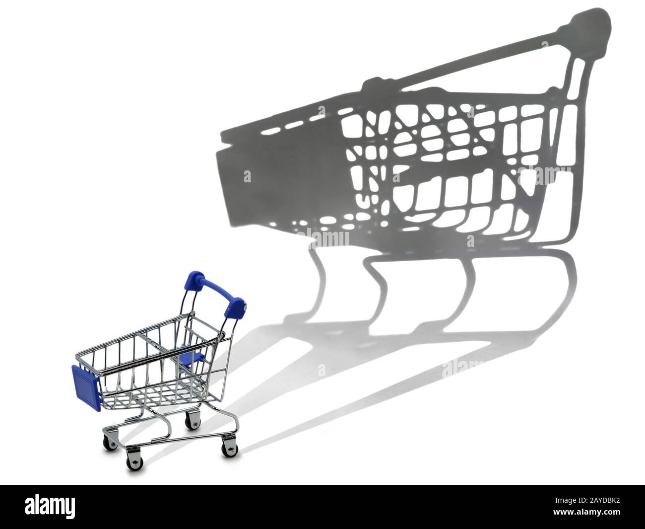 shopping cart casts a large shadow on white background, concept of ...