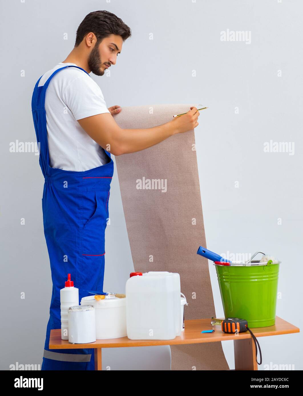 Worker working on wallpaper during refurbishment Stock Photo - Alamy