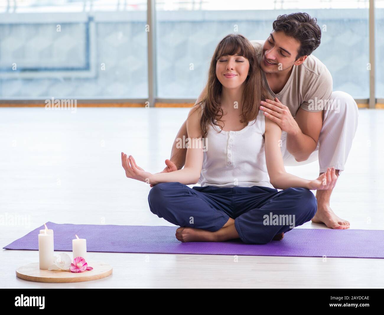 Personal coach helping during yoga session Stock Photo - Alamy