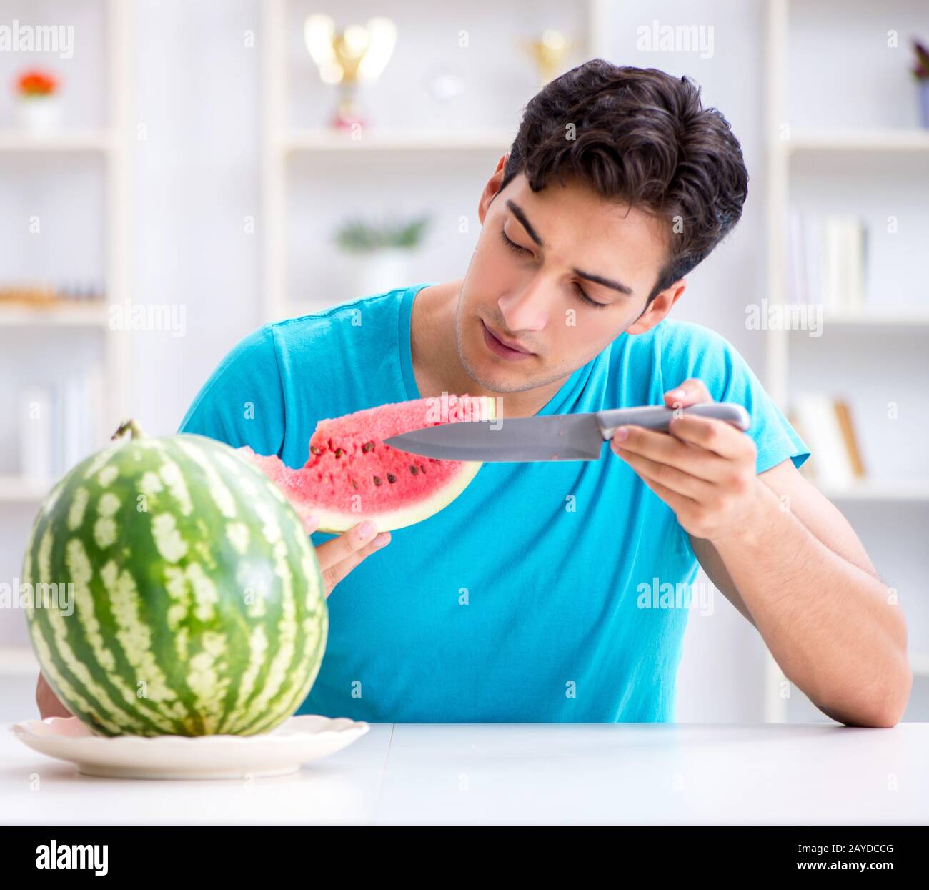 Man eating watermelon at home Stock Photo - Alamy