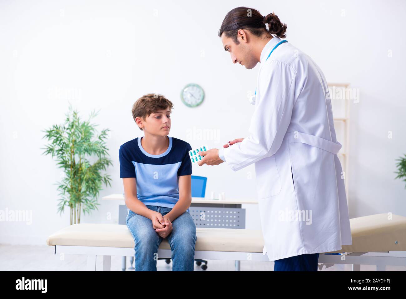 Young male doctor examining boy in the clinic Stock Photo - Alamy