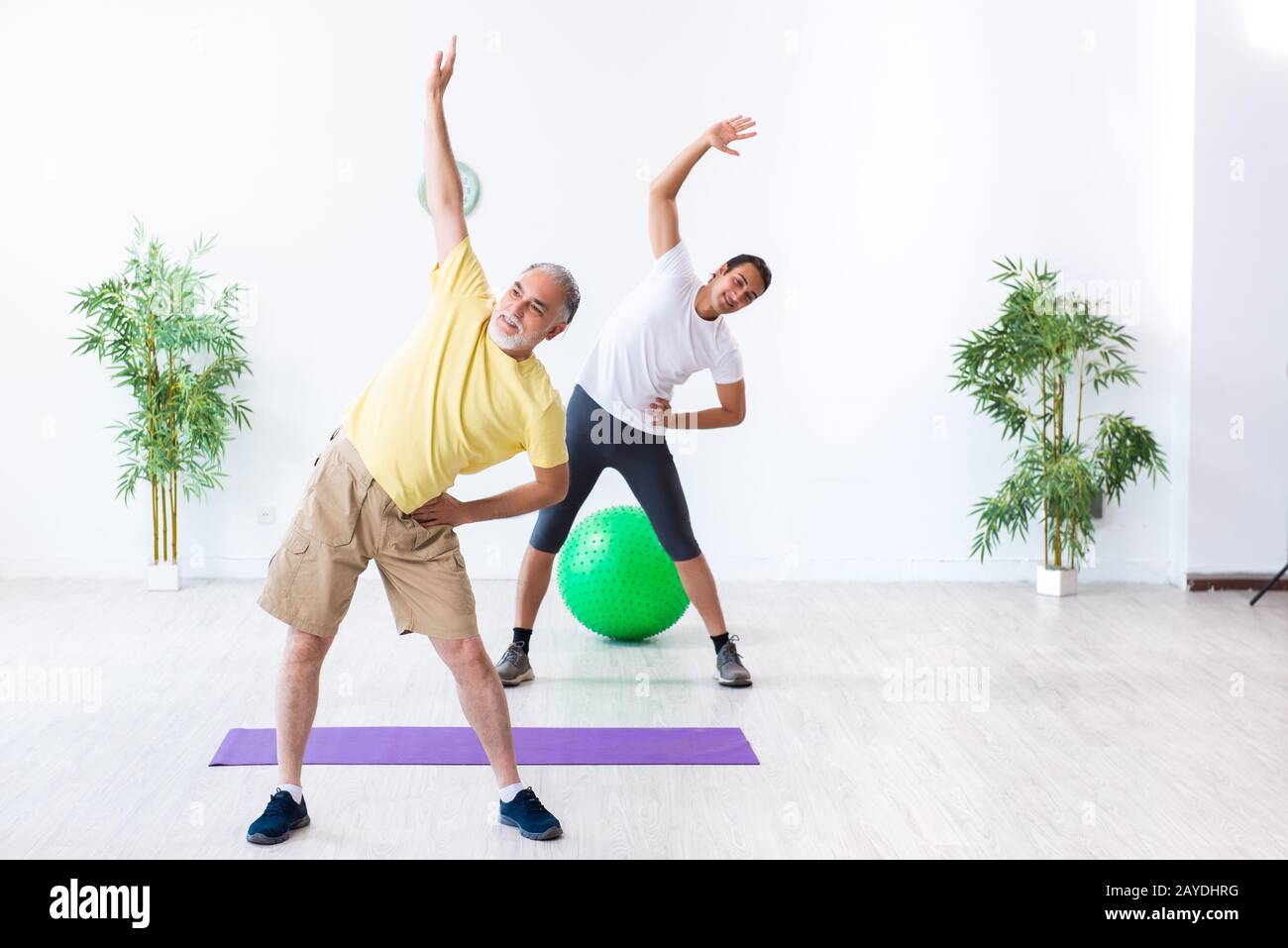 Old man doing exercises indoors Stock Photo - Alamy