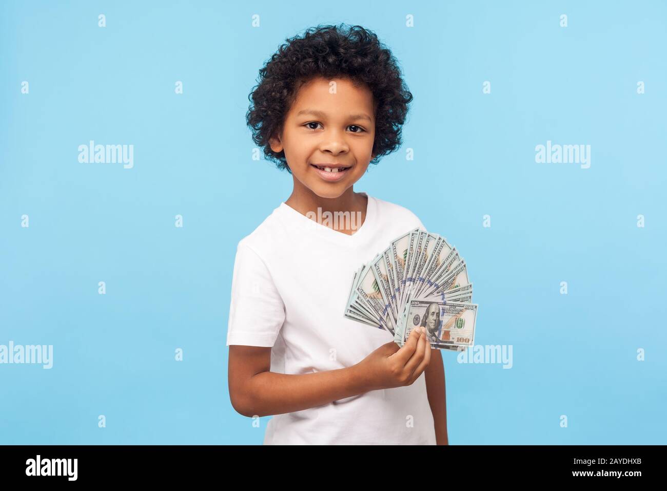 Cute smart wealthy little boy with curly hair in T-shirt holding fan of ...