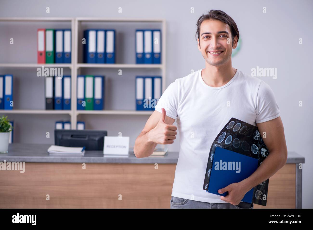 Young man at hospital reception desk Stock Photo - Alamy