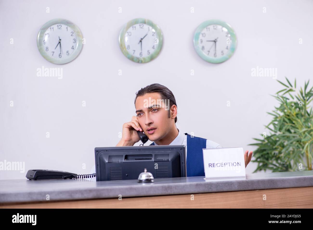 Young man receptionist at the hotel counter Stock Photo - Alamy