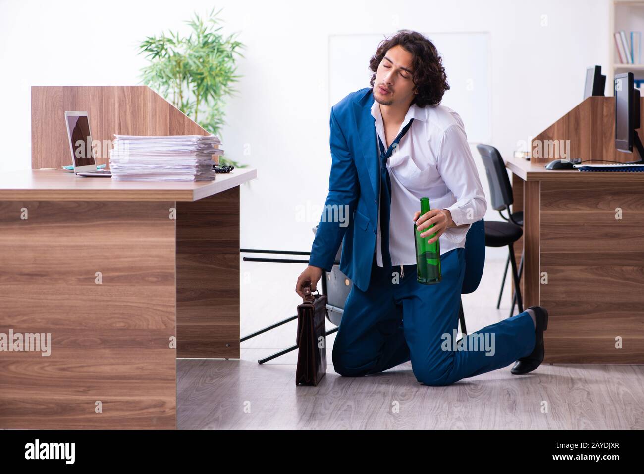 Young drunk employee in the office Stock Photo - Alamy