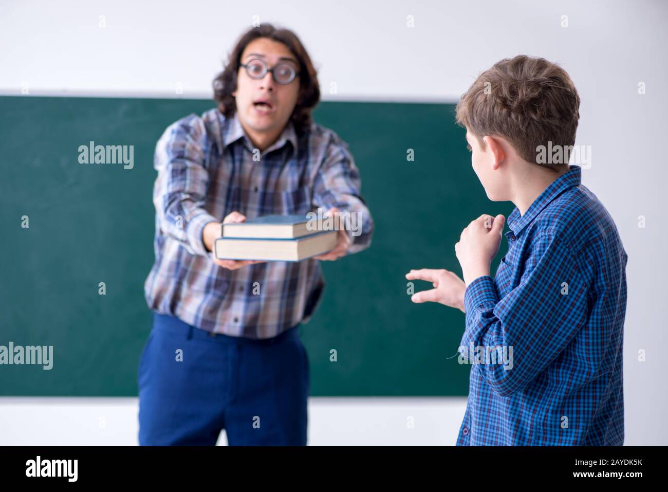 Funny male teacher and boy in the classroom Stock Photo - Alamy
