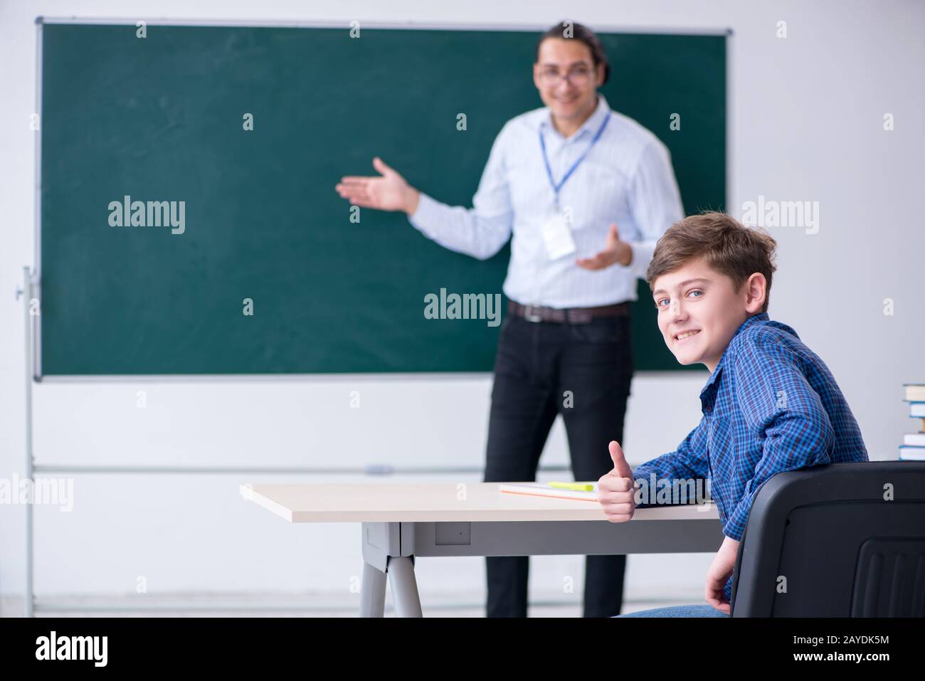 Young male teacher and boy in the classroom Stock Photo - Alamy