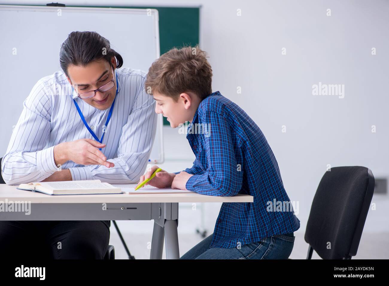 Young male teacher and boy in the classroom Stock Photo - Alamy