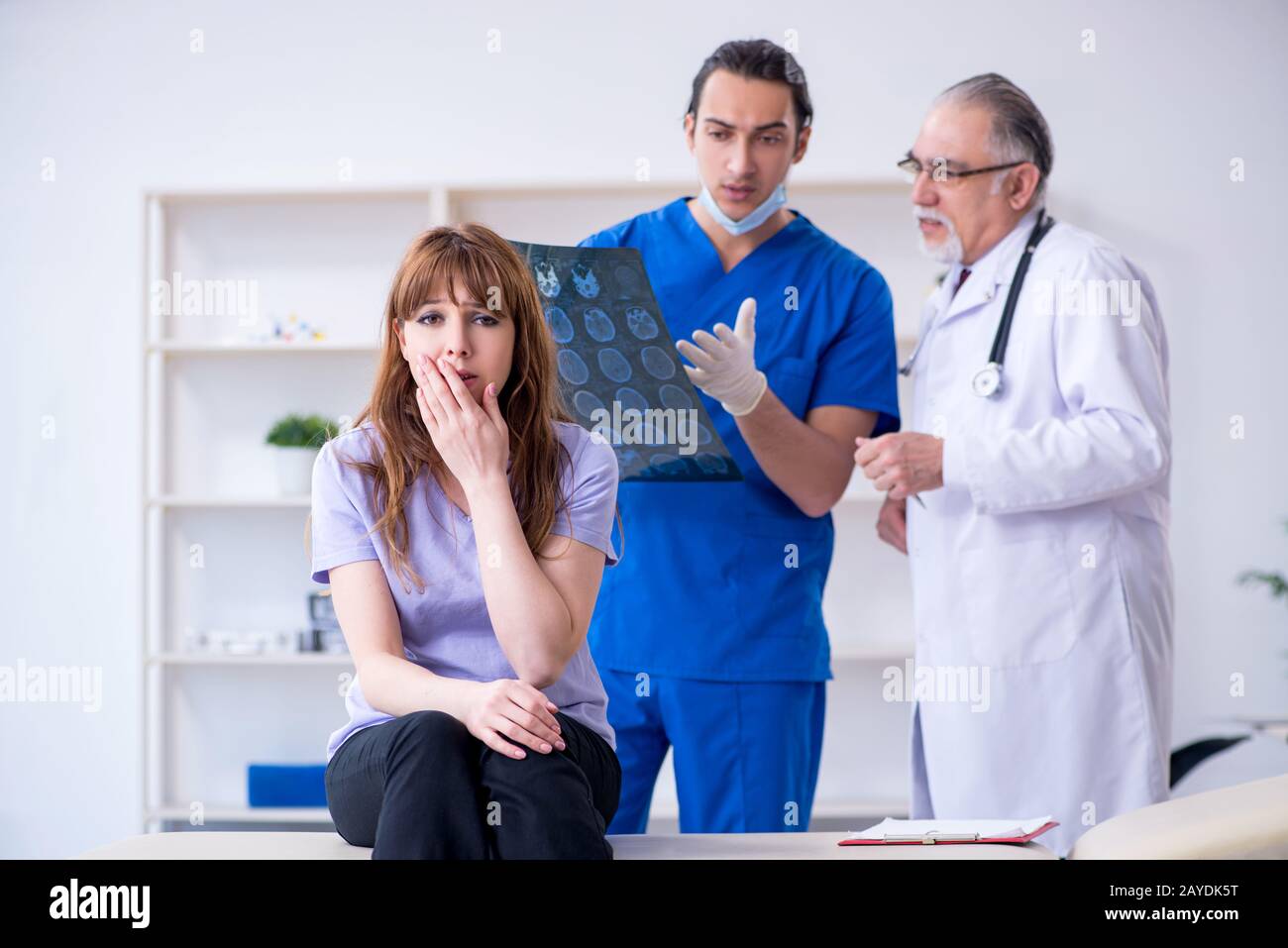 Two doctors examining young woman Stock Photo - Alamy