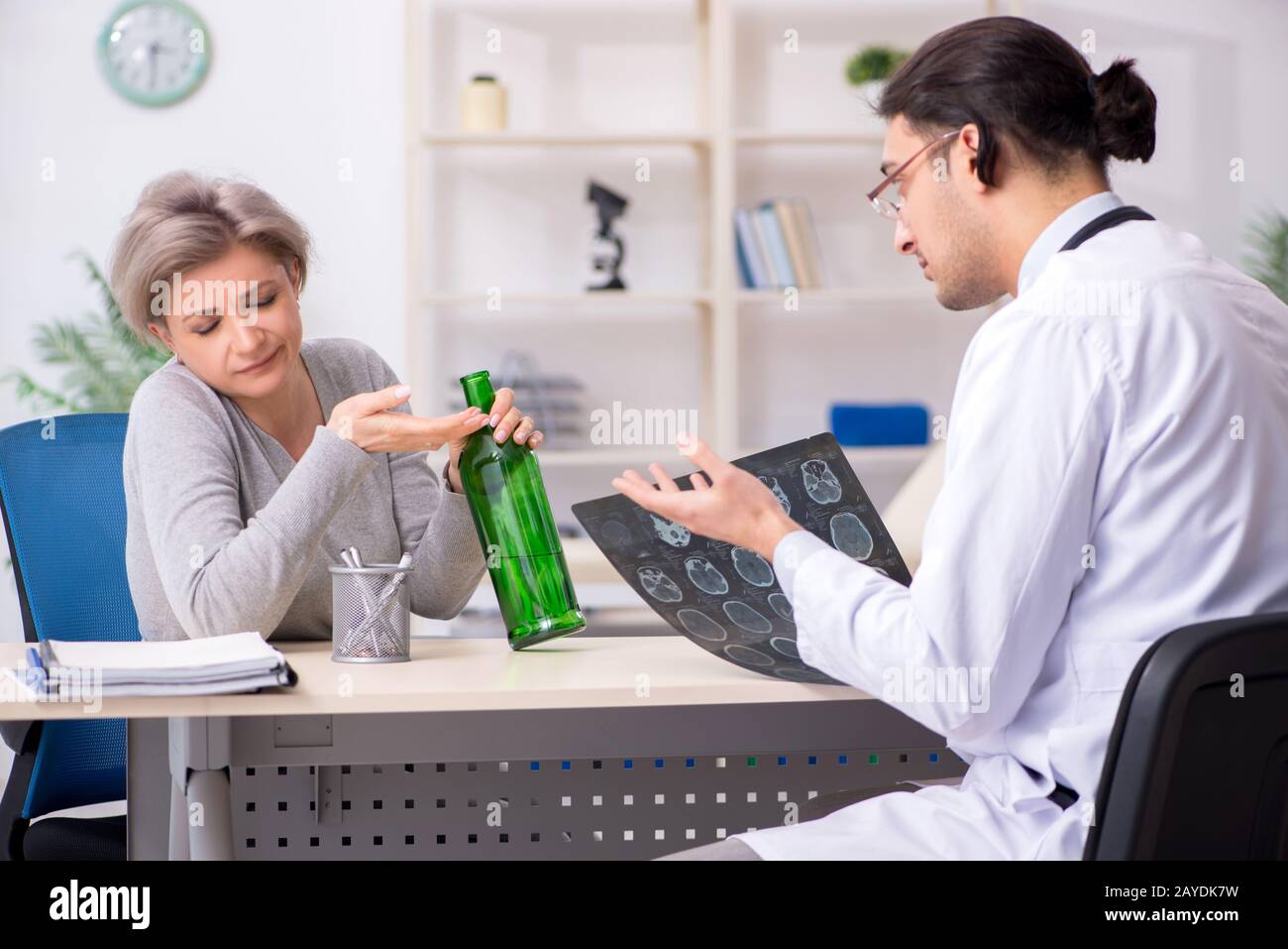 Female alcoholic visiting young male doctor Stock Photo - Alamy