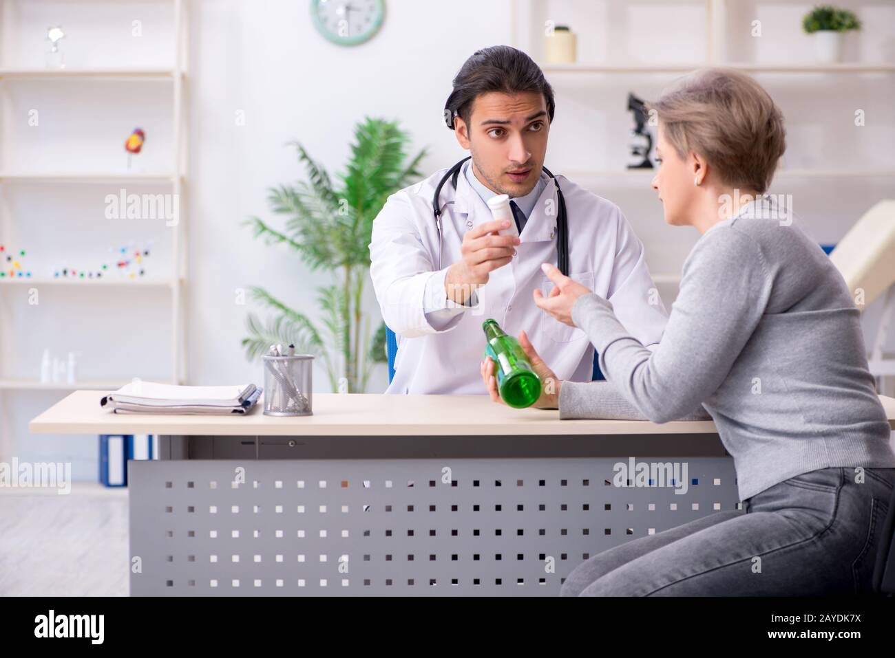 Female alcoholic visiting young male doctor Stock Photo - Alamy
